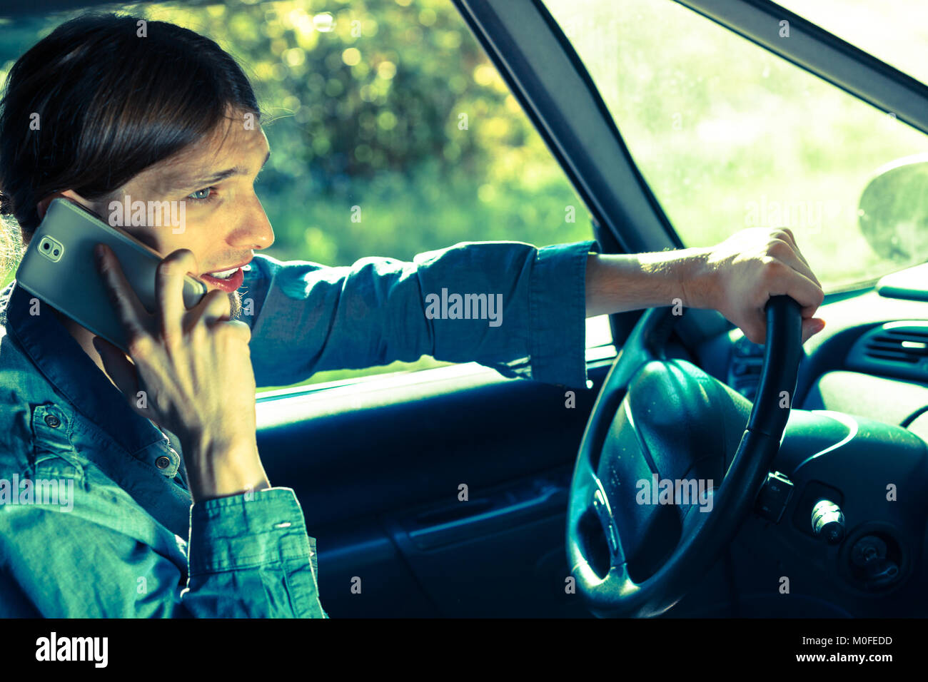 Talking while drive, danger fresh driver concept. Young man driving car ...