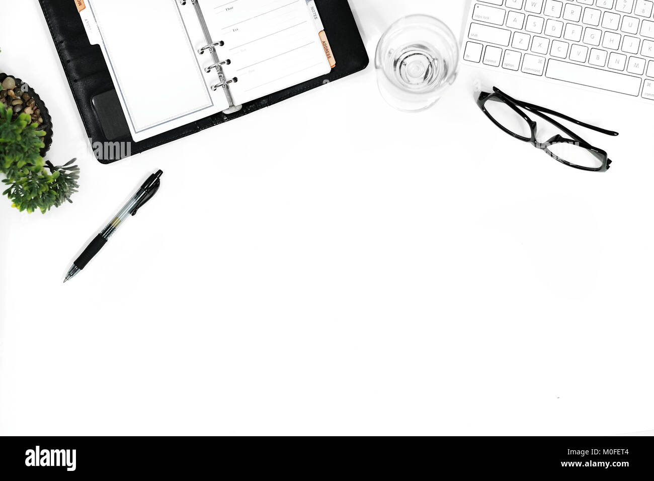 Conceptual,White office desk table with diary on a white table. open ...