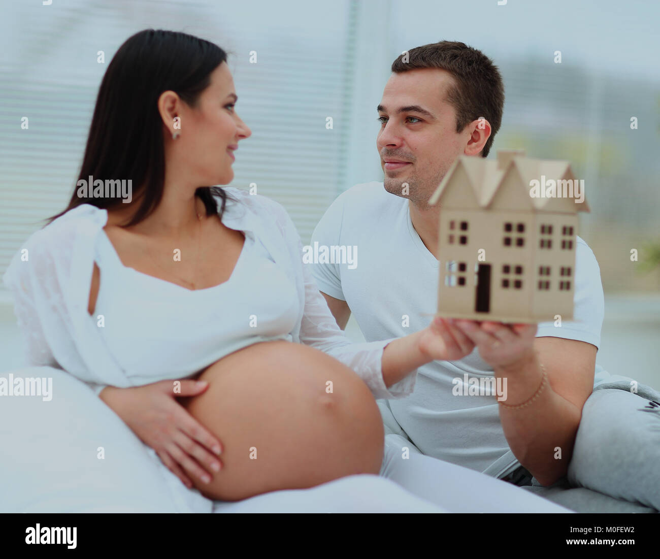 man demonstrates his pregnant wife the model of the future home Stock ...