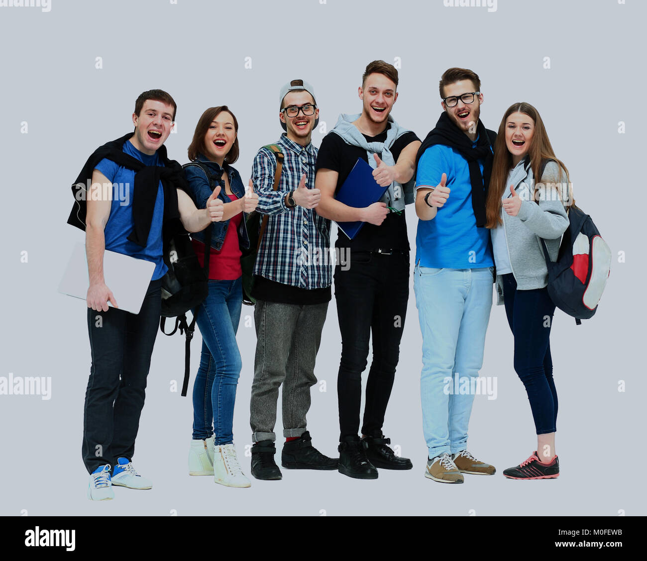 group of smiling friends staying together and looking at camera ...