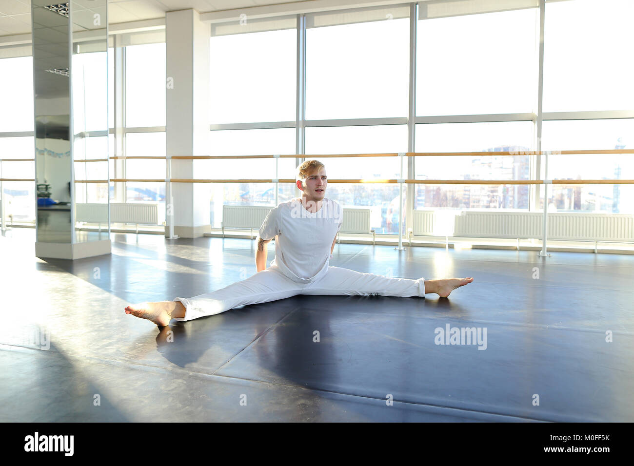 Man training at studio in white suit Stock Photo - Alamy
