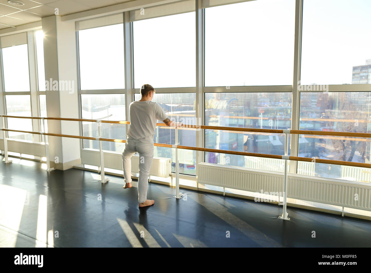 Gymnast in sportswear training near ballet barre in sport gym Stock ...