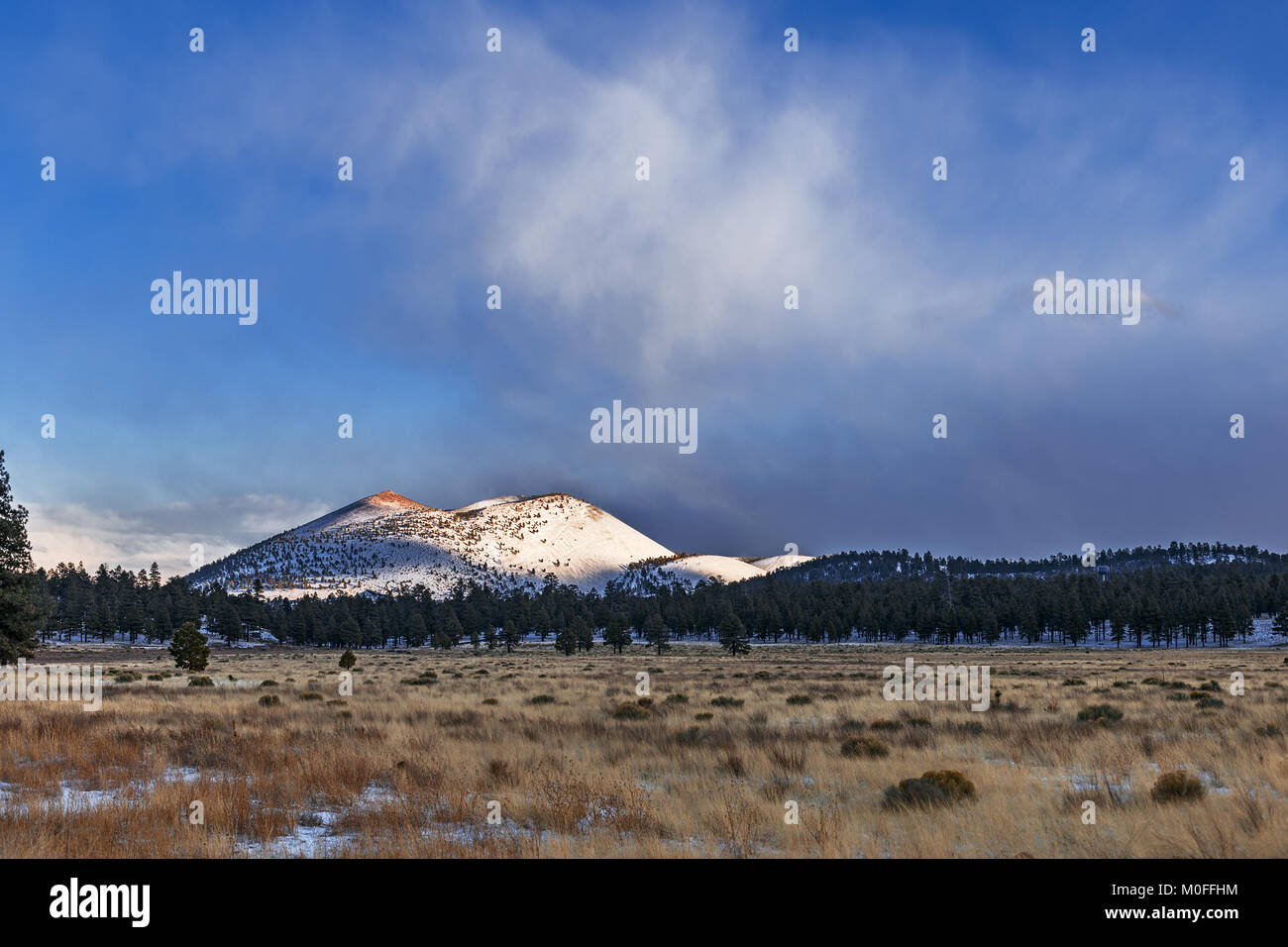 The Sunset Crater volcano with snow as a winter storm begins to clear ...
