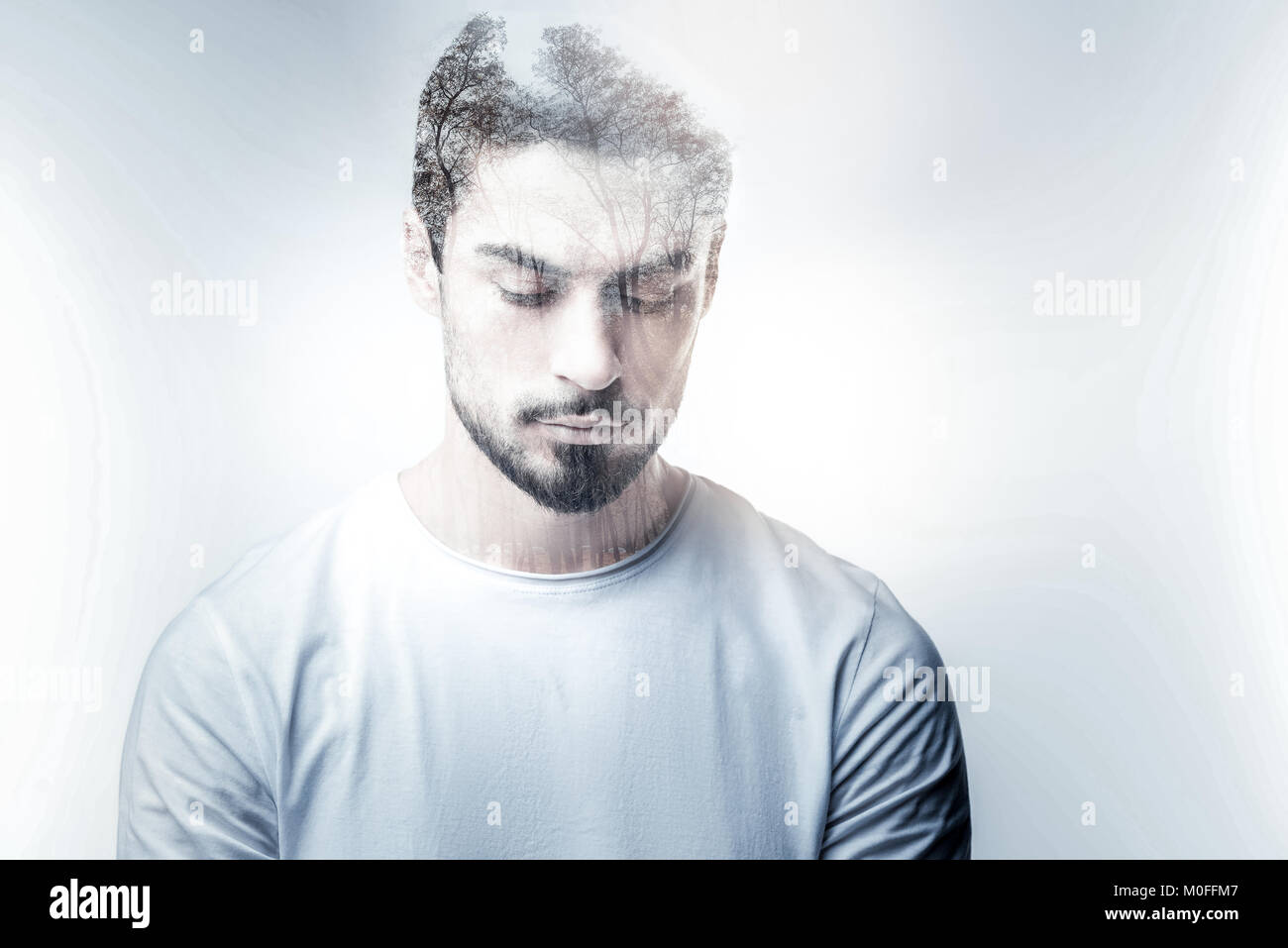 Thoughtful young man bowing his head Stock Photo - Alamy