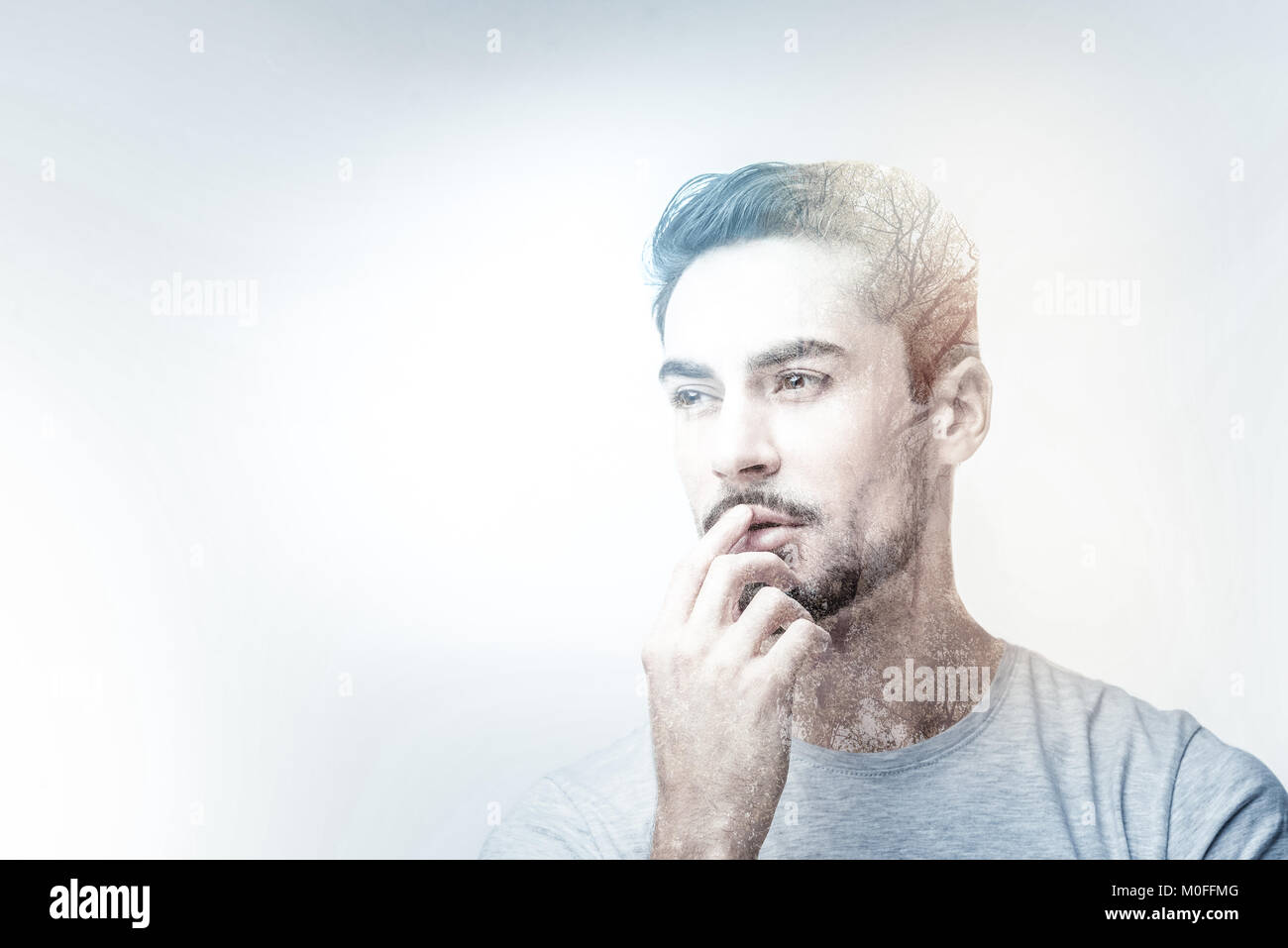 Thoughtful young man standing against suburban background Stock Photo ...