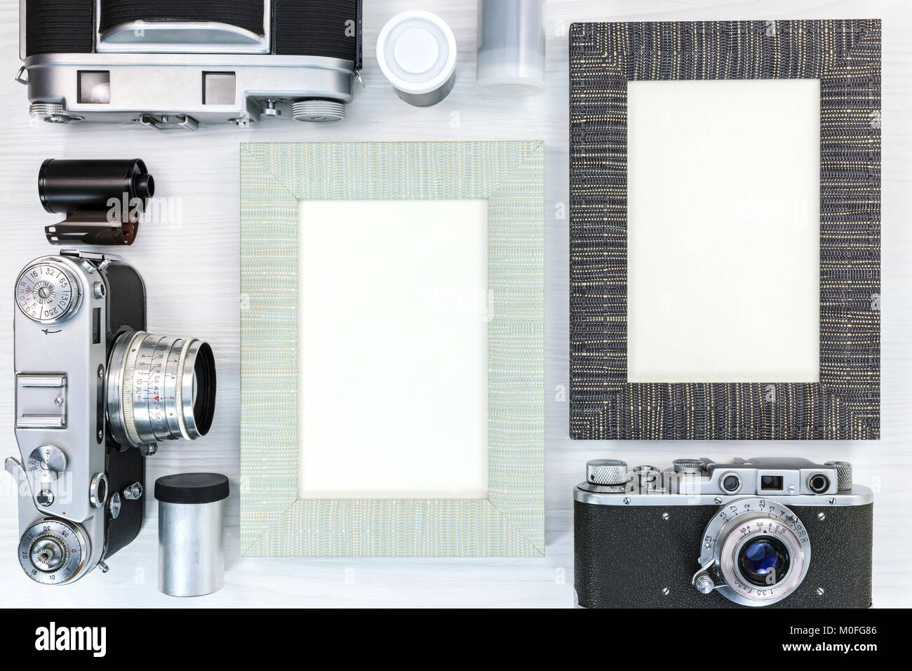old classic photo cameras, wooden frames, films rolls on white wooden ...