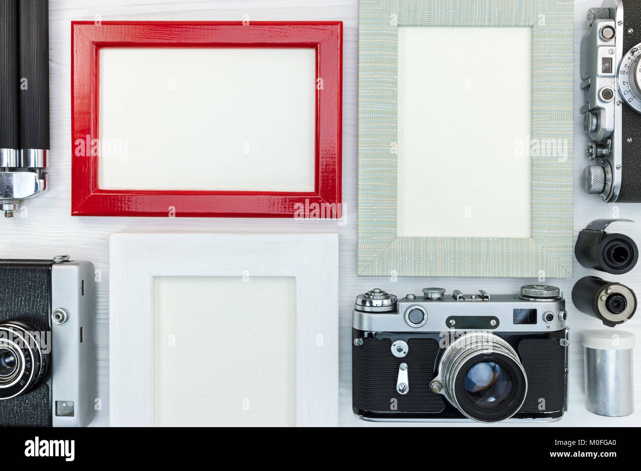 empty photo frames and retro cameras with equipment on white wooden ...