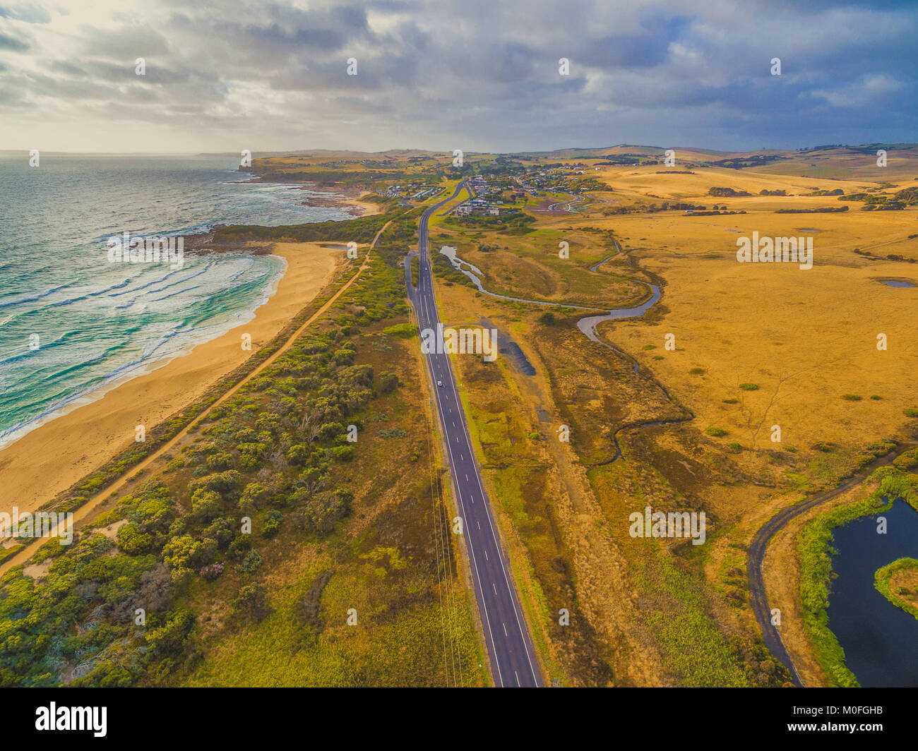 Aerial view of Bass Highway passing near the ocean and leading into ...