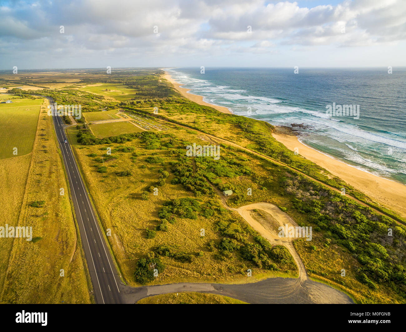 Aerial view of ocean coastline and straight rural highway in Australia ...