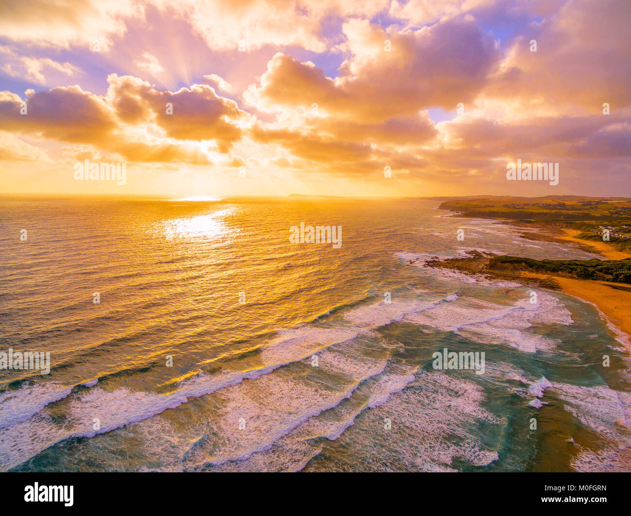 Vivid glowing sunset over ocean and coastline in Australia - aerial ...