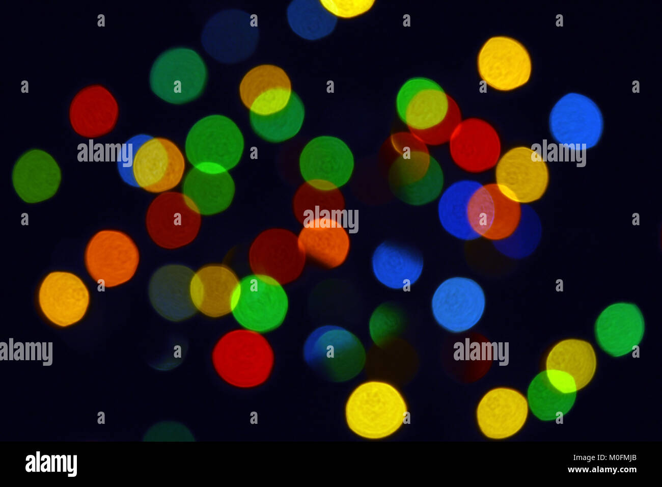 Bright circles of defocused color light on black background Stock Photo ...