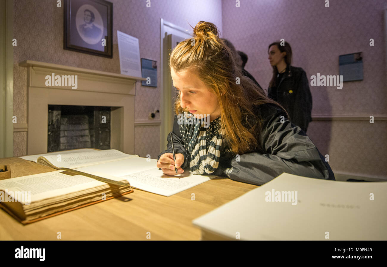 Young female writes passage of Emily Bront‘'s Wuthering Heights at ...