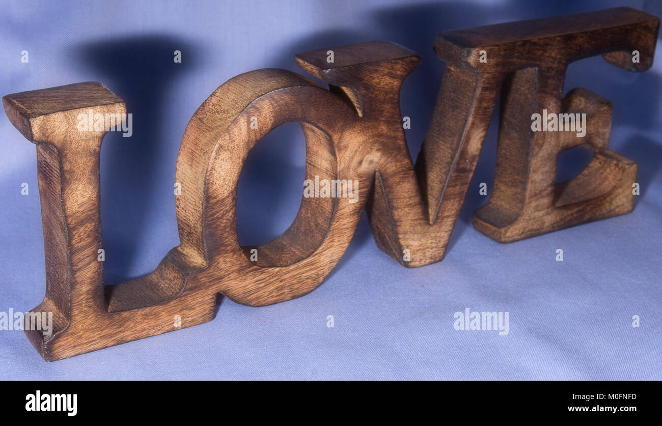 Wooden love sign on a blue background Stock Photo - Alamy