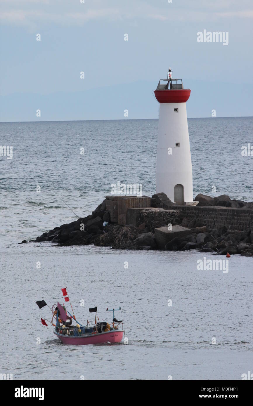 Boat passing Lighthouse Stock Photo - Alamy