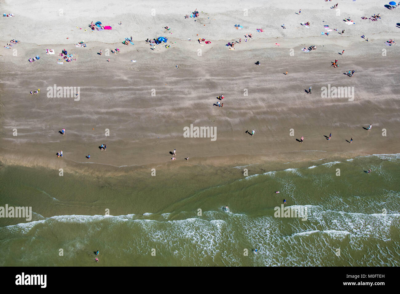 Aerial of beachgoers enjoying the sun and sand on coastline of South ...