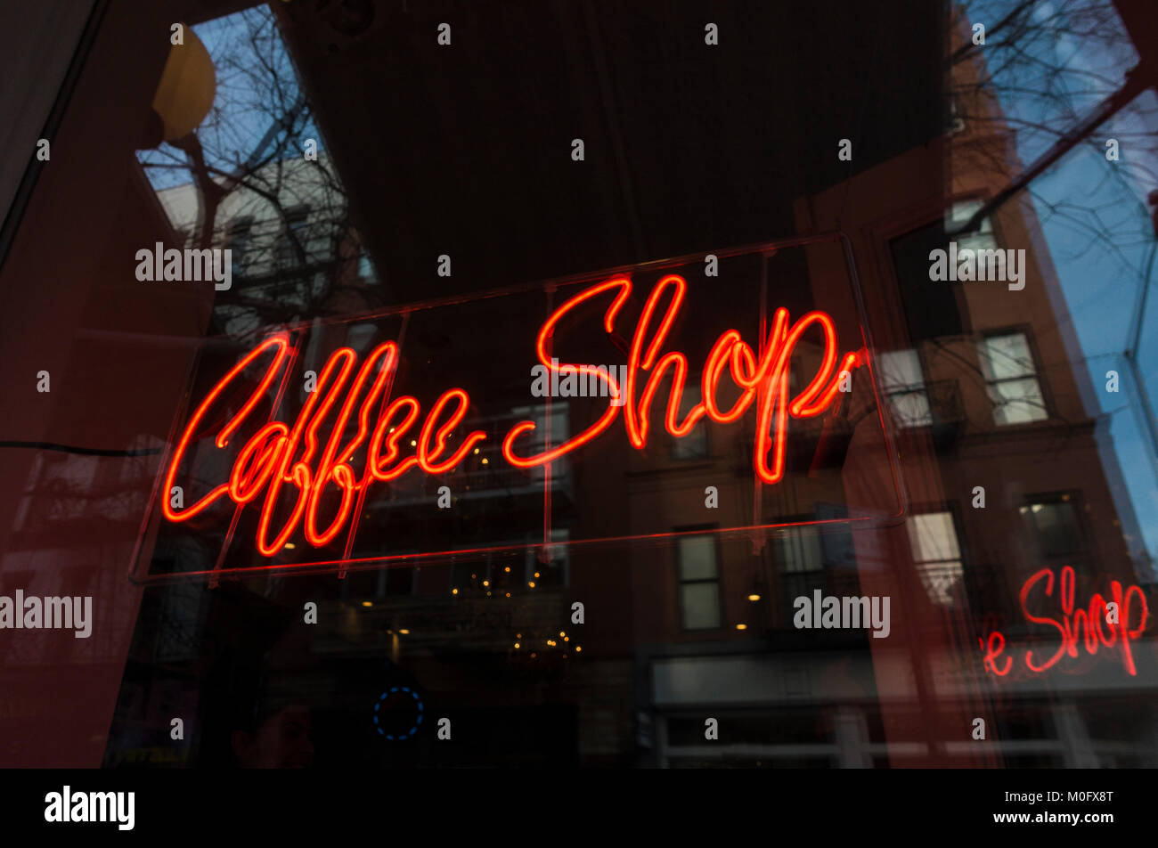 A bright red neon sign in the window of a New York City coffee shop ...