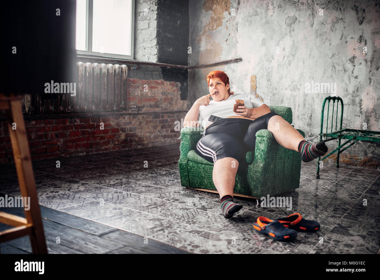 Fat woman sits in a chair and eats sweets, overweight. Unhealthy ...