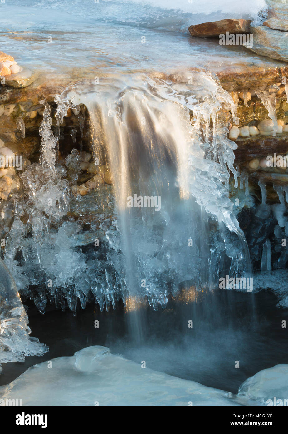 Iced over waterfall that is still spilling water Stock Photo - Alamy