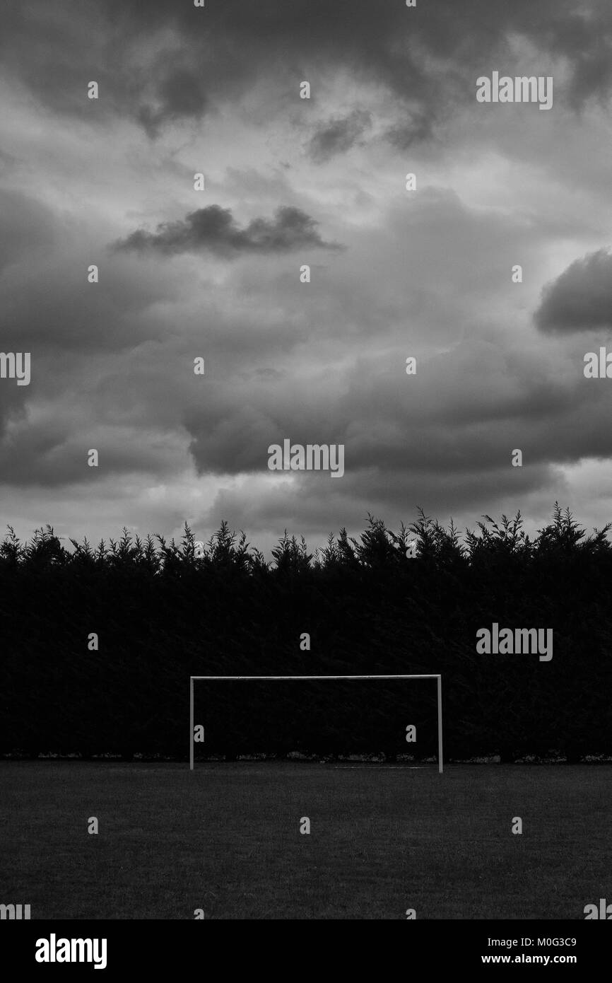 Storm clouds gather over an empty football pitch. (B/W Stock Photo - Alamy