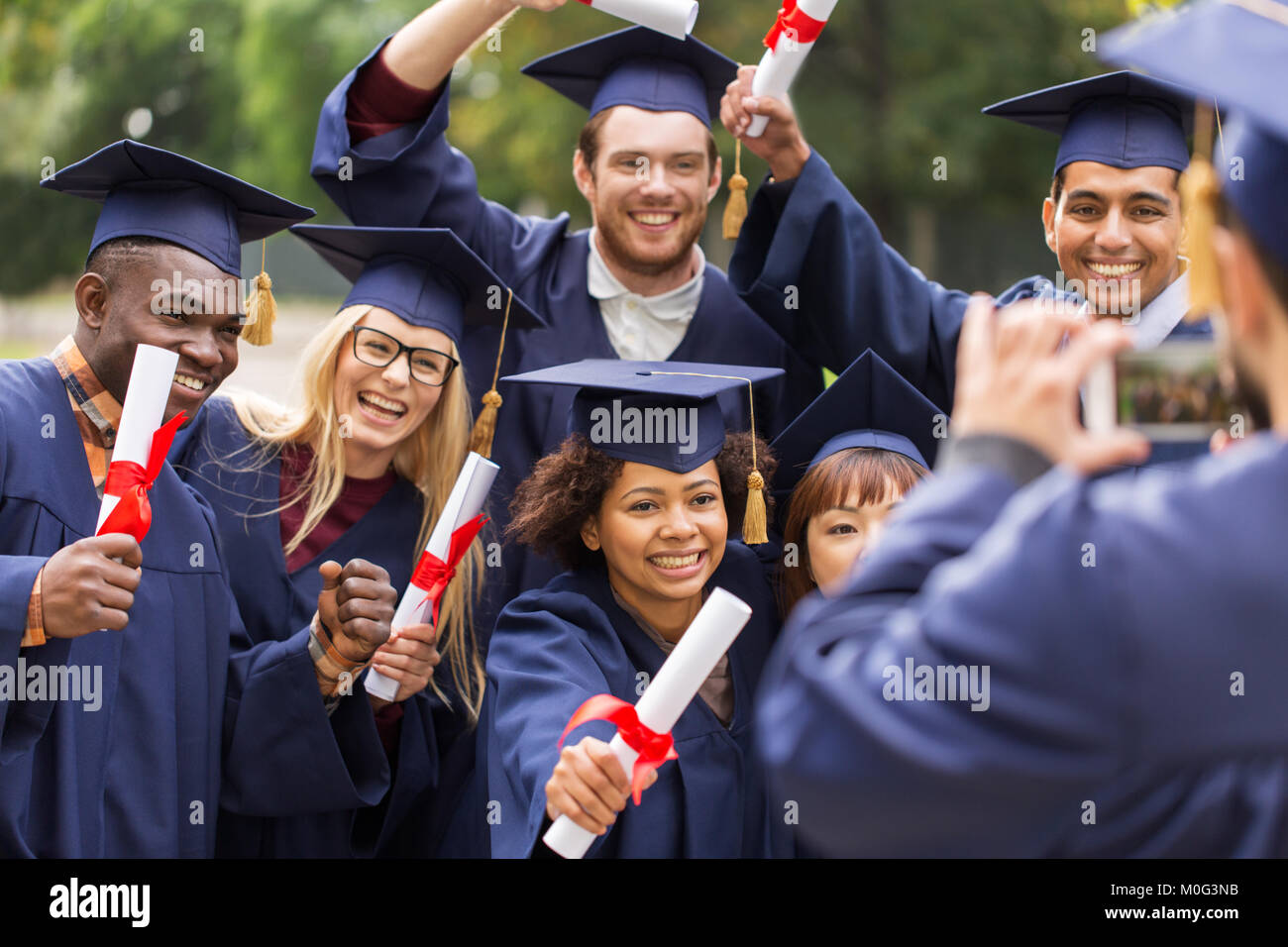 students or graduates with diplomas taking picture Stock Photo - Alamy