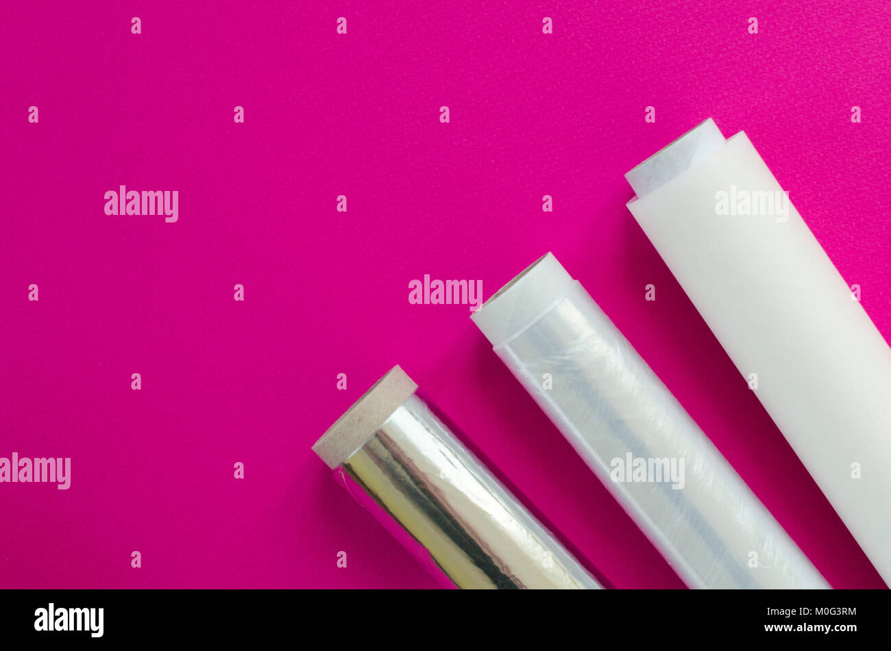 Plastic wrap, aluminum foil, parchment paper on pink background Stock ...