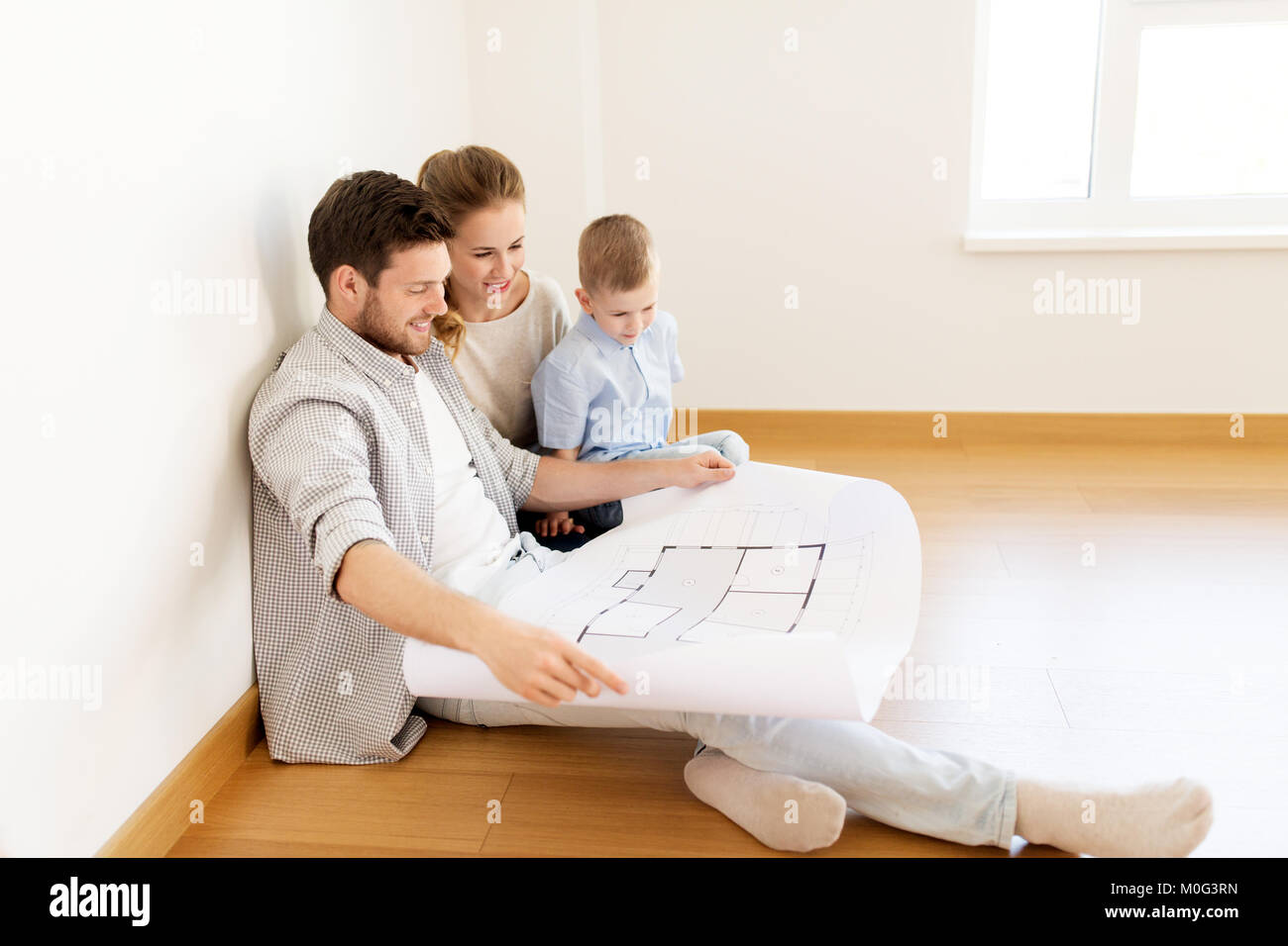 happy family with blueprint moving to new home Stock Photo - Alamy