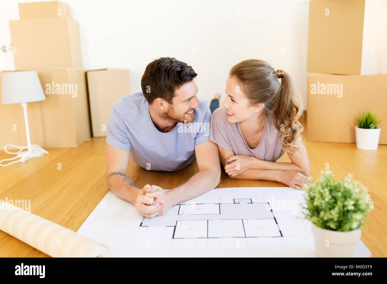 couple with boxes and blueprint moving to new home Stock Photo - Alamy