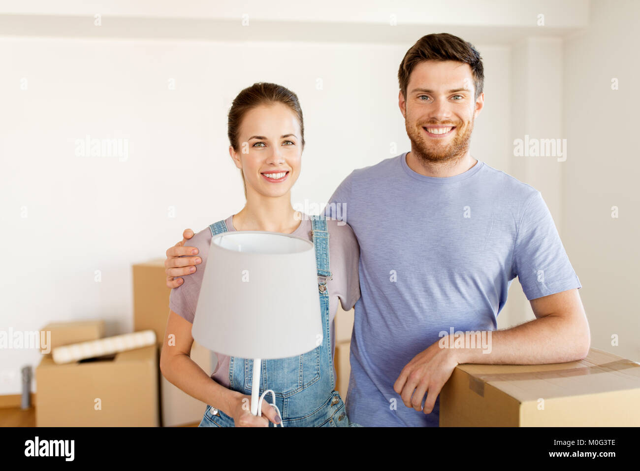couple with boxes and lamp moving to new home Stock Photo - Alamy