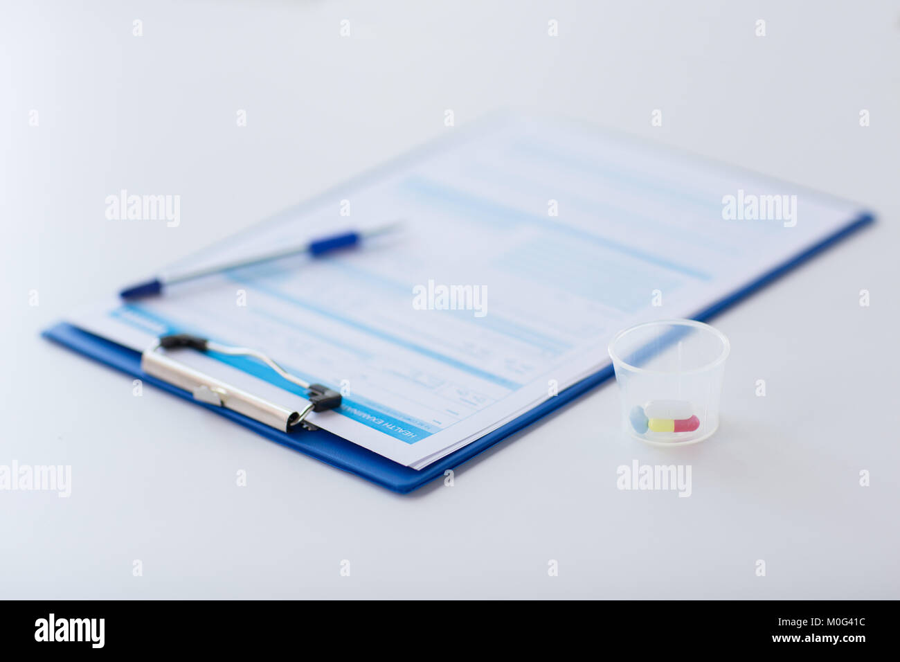 clipboard with report and drugs in medical cup Stock Photo - Alamy