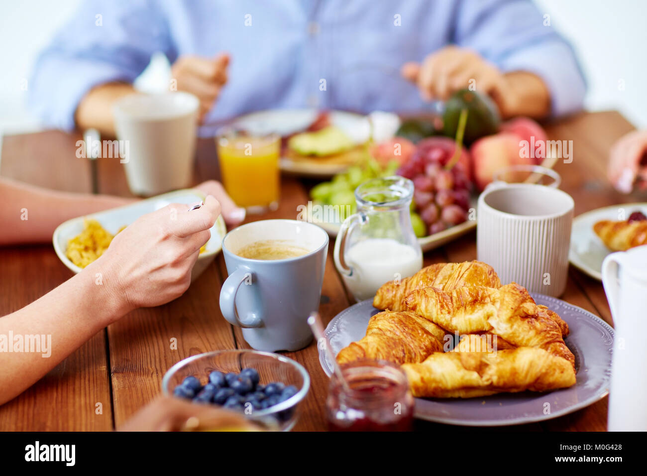 close up of people eating food at table Stock Photo - Alamy
