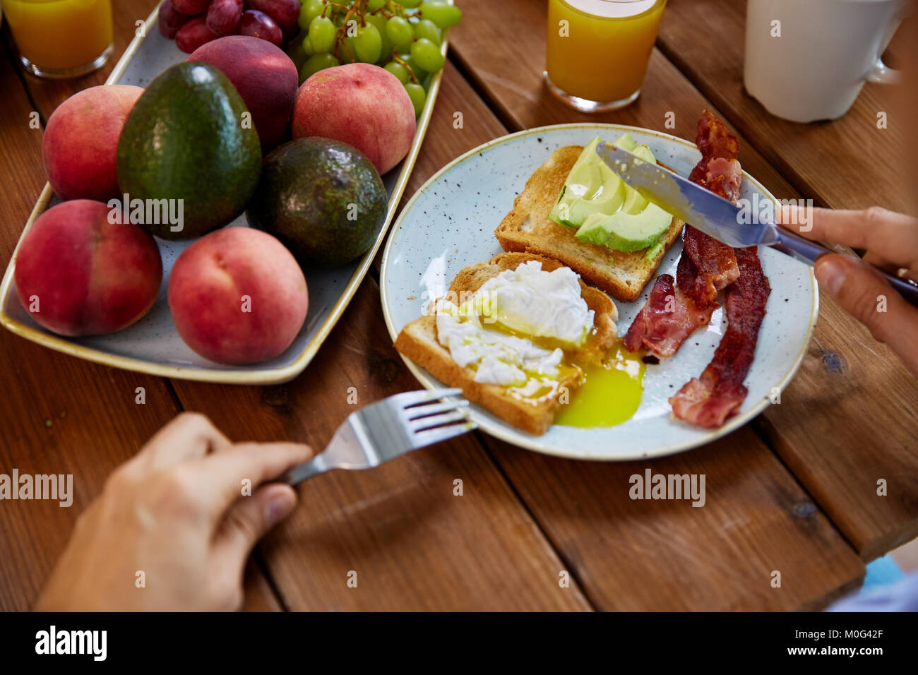 man eating toast with pouched egg and bacon Stock Photo - Alamy