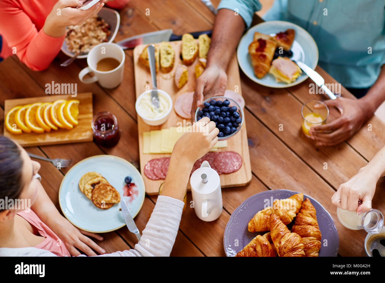 people having breakfast at table with food Stock Photo - Alamy