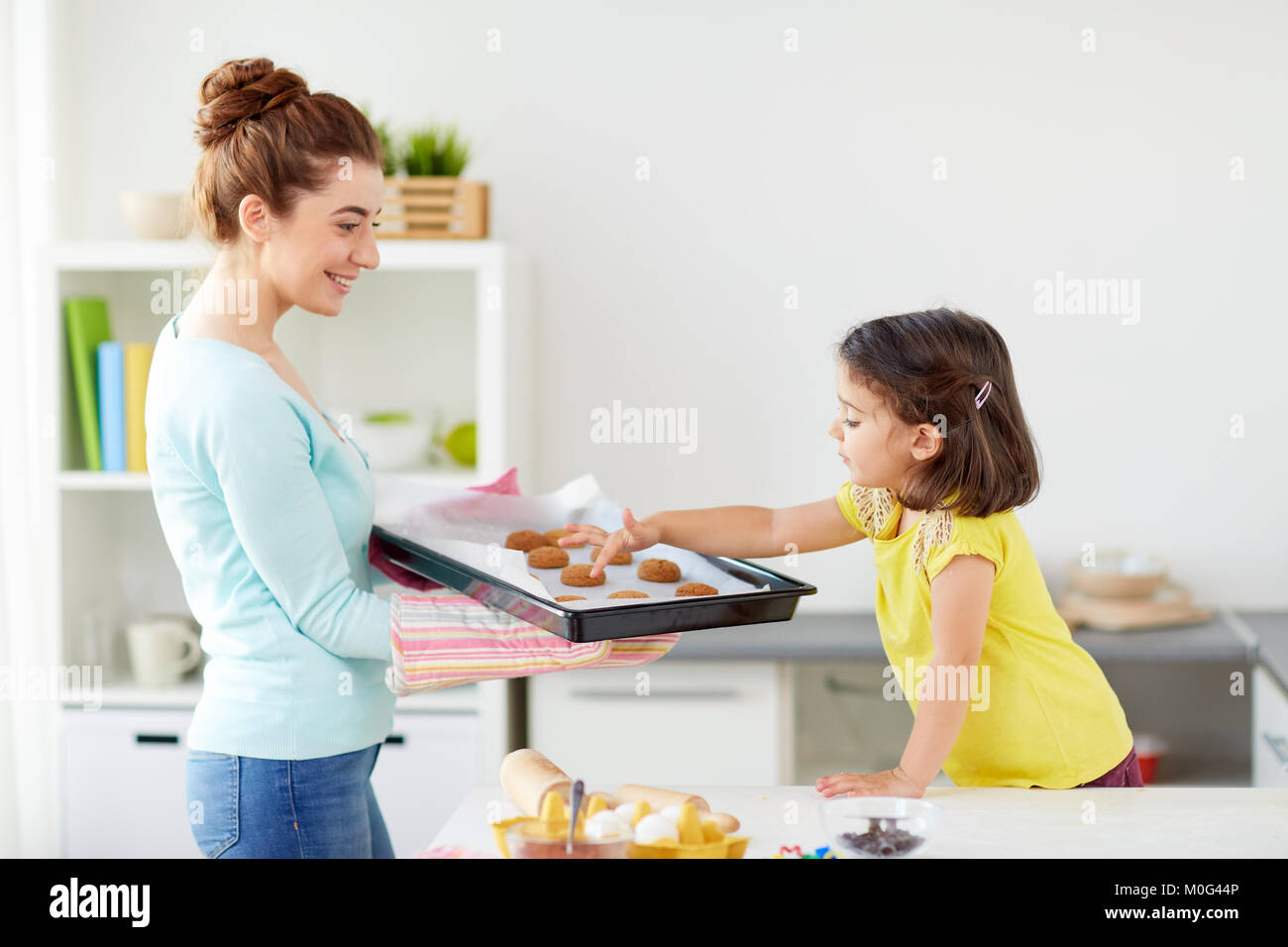 happy mother and daughter baking cookies at home Stock Photo - Alamy