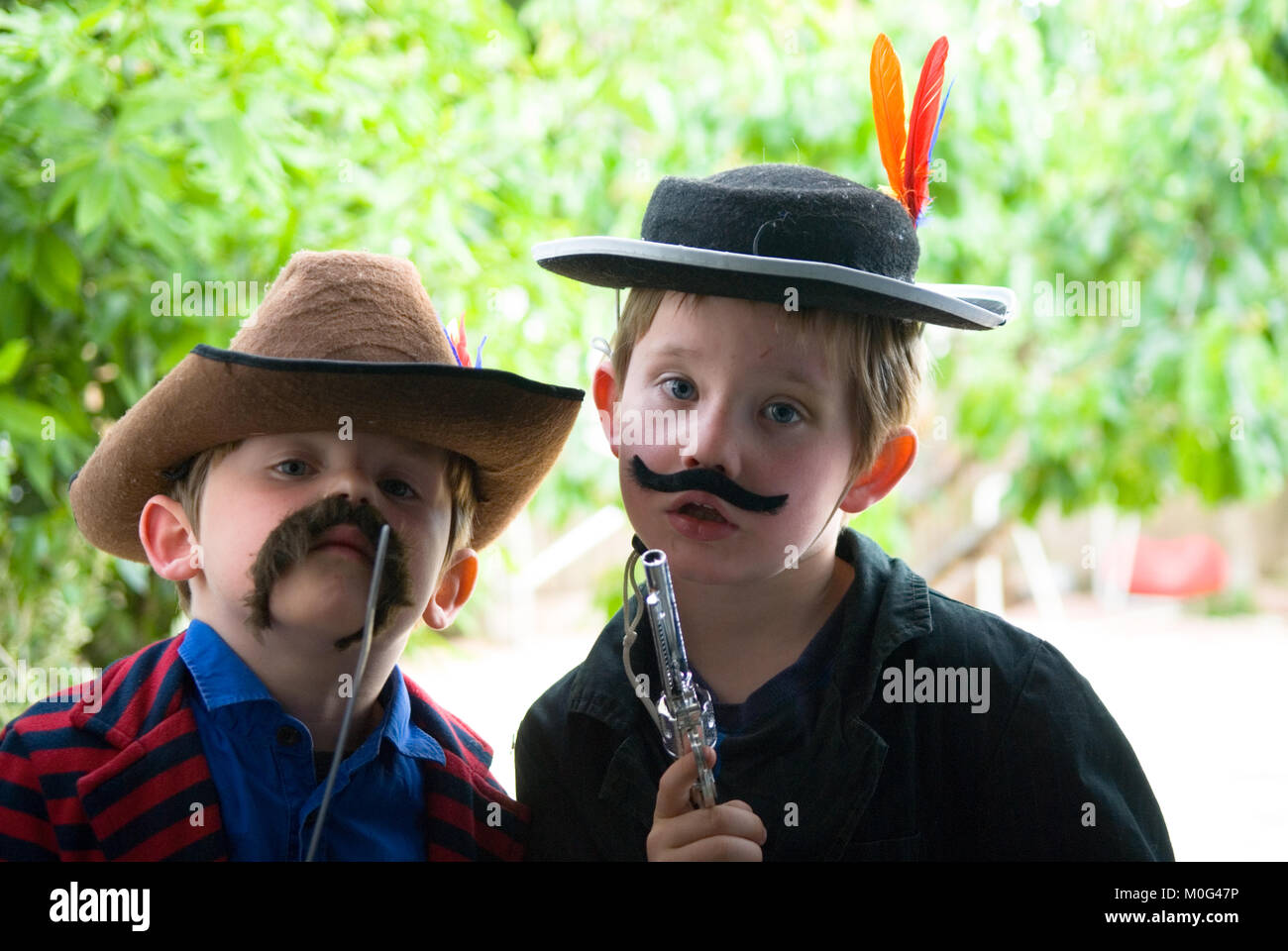 close up portrait of five year old twin brothers dressed up as cowboys ...