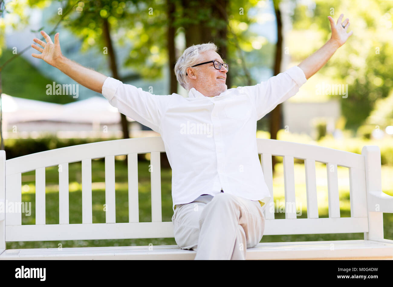 happy senior man sitting on bench at summer park Stock Photo - Alamy