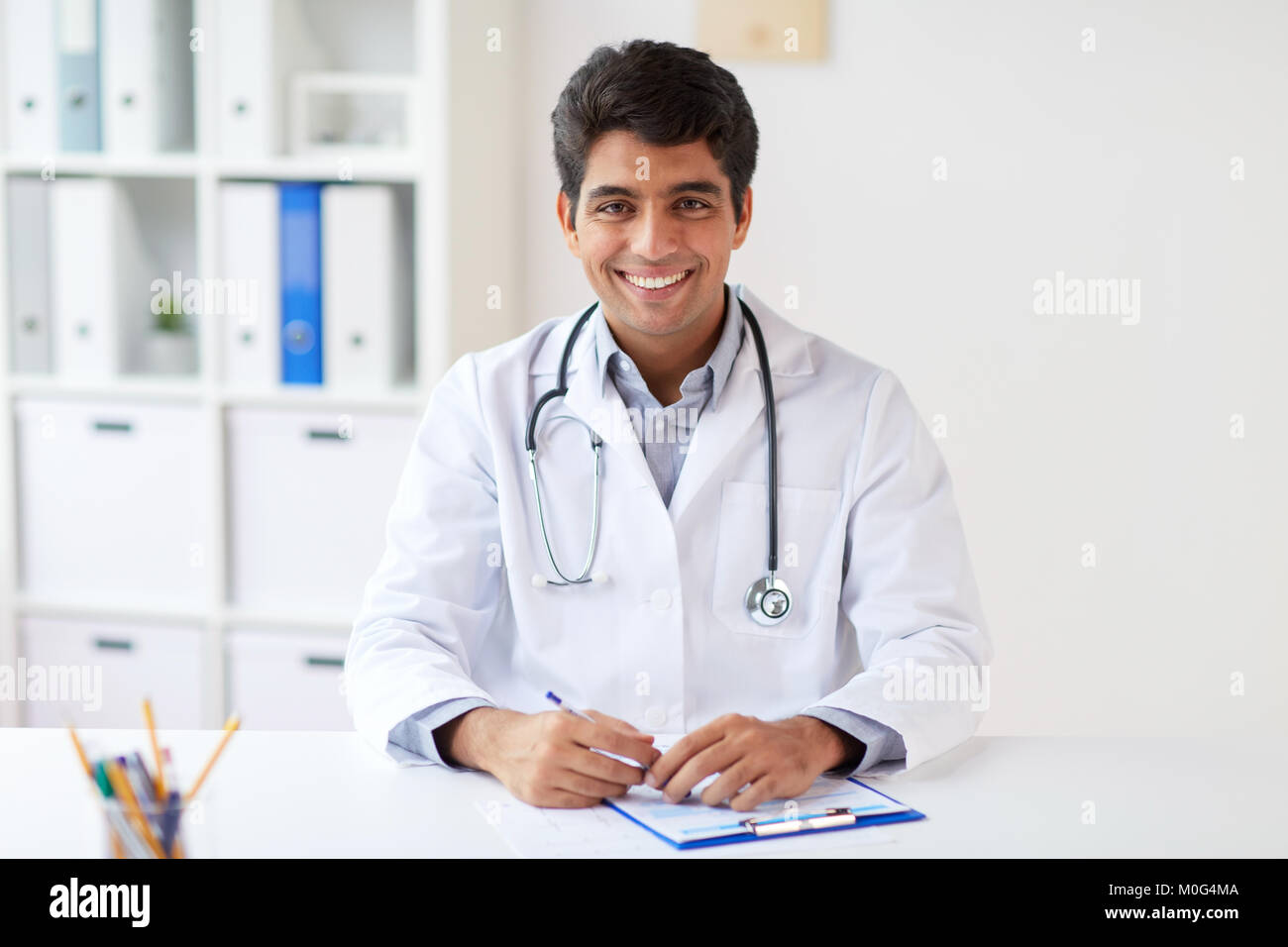 happy doctor with clipboard at clinic Stock Photo - Alamy