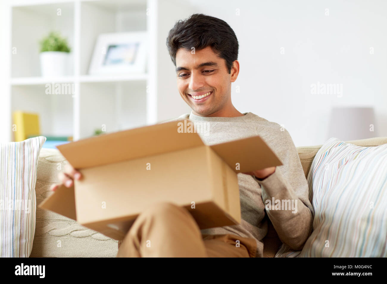 happy man opening parcel box at home Stock Photo - Alamy