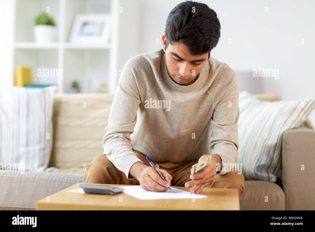 man with money and calculator filling papers Stock Photo - Alamy