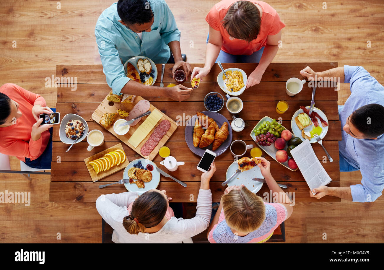 people with smartphones eating food at table Stock Photo - Alamy