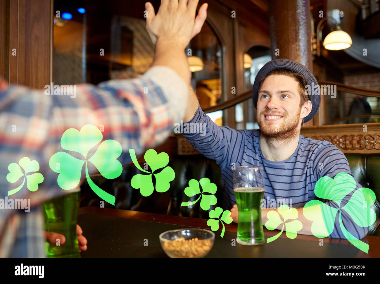 friends with green beer making high five at pub Stock Photo - Alamy