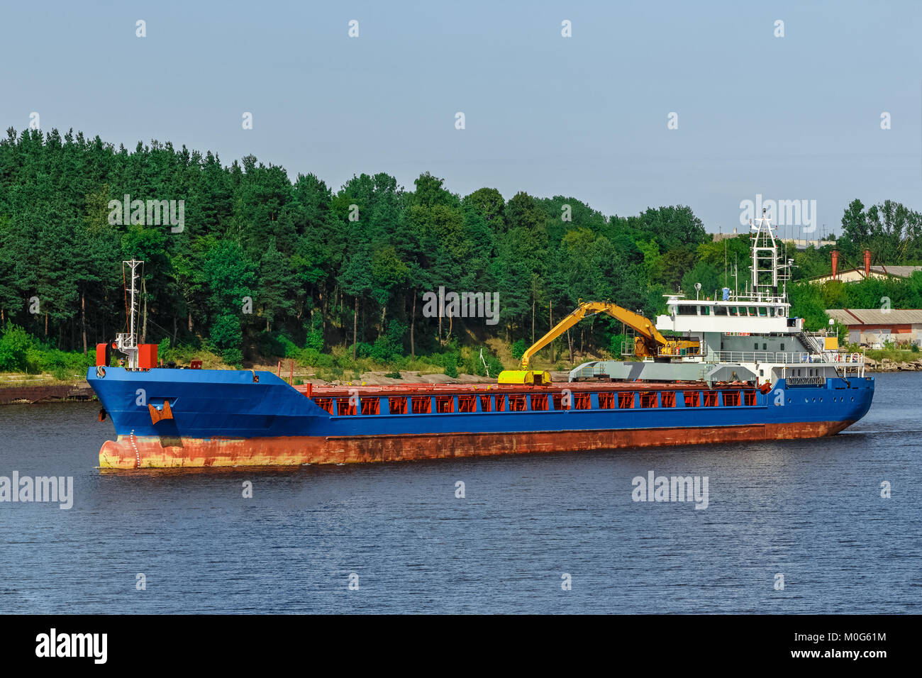 Blue cargo ship with long reach excavator moving to the port Stock ...