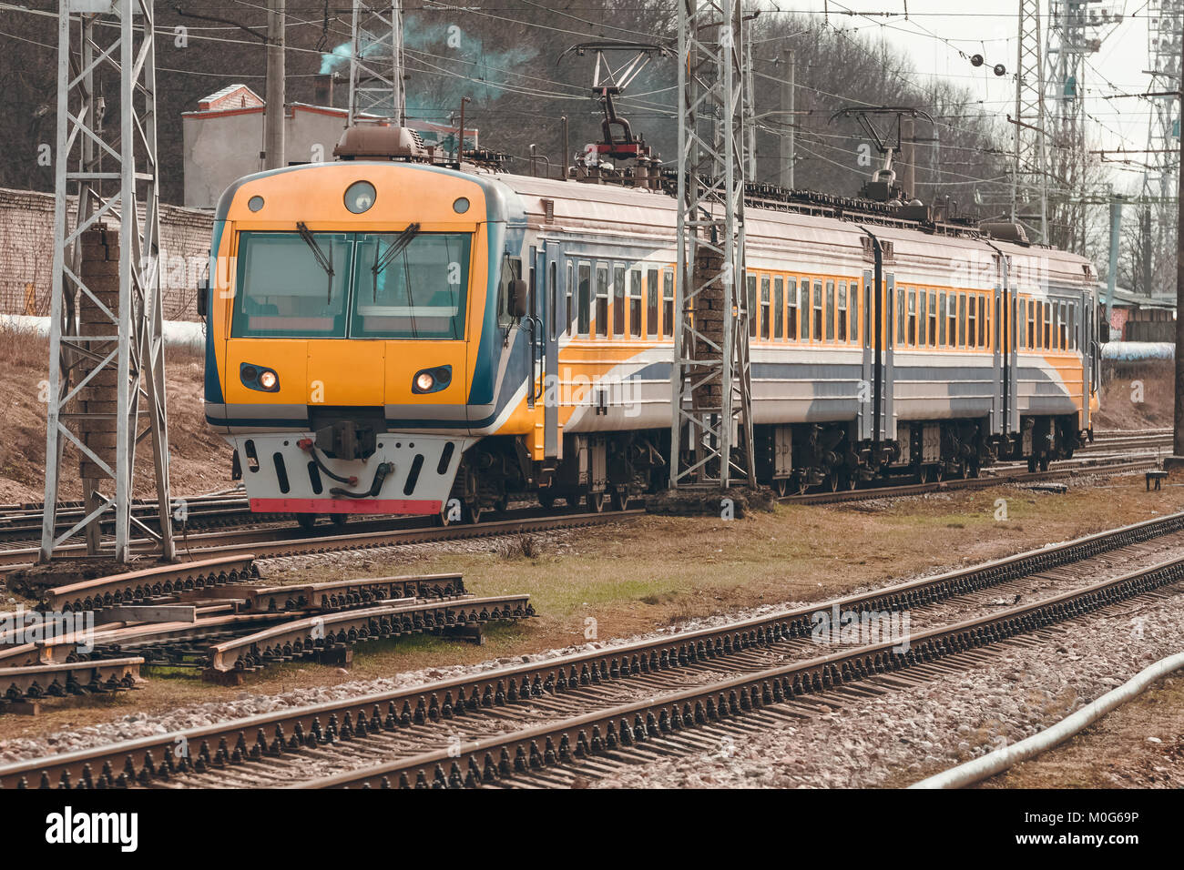 Yellow modern passenger electric train moving at the old terminal Stock ...