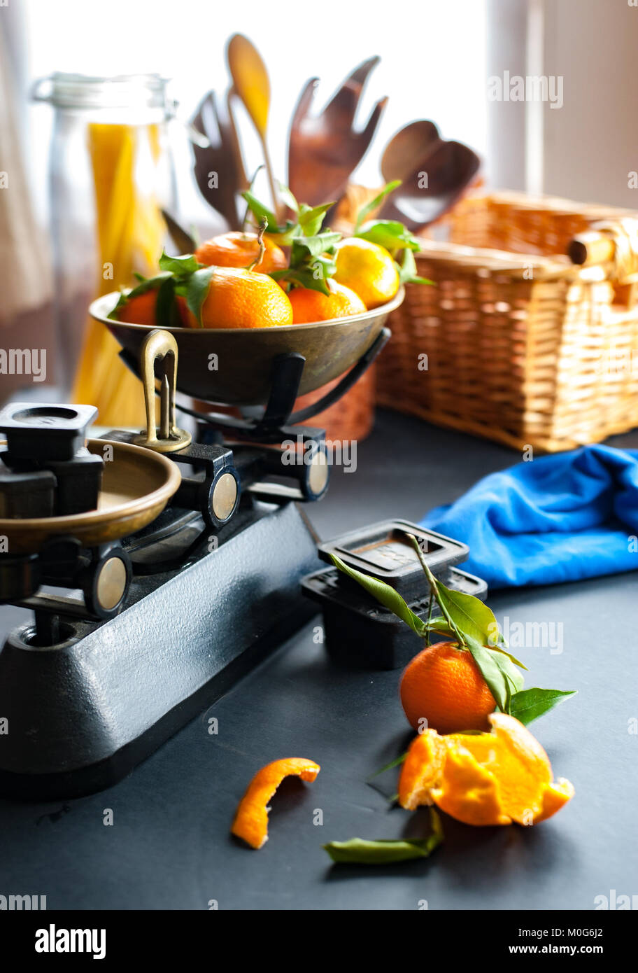 Fresh whole clementines with green leaves in vintage scale and one ...