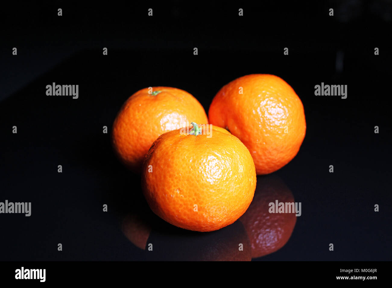 Mandarins. Mandarin citrus orange fruit mandarins on black reflective ...