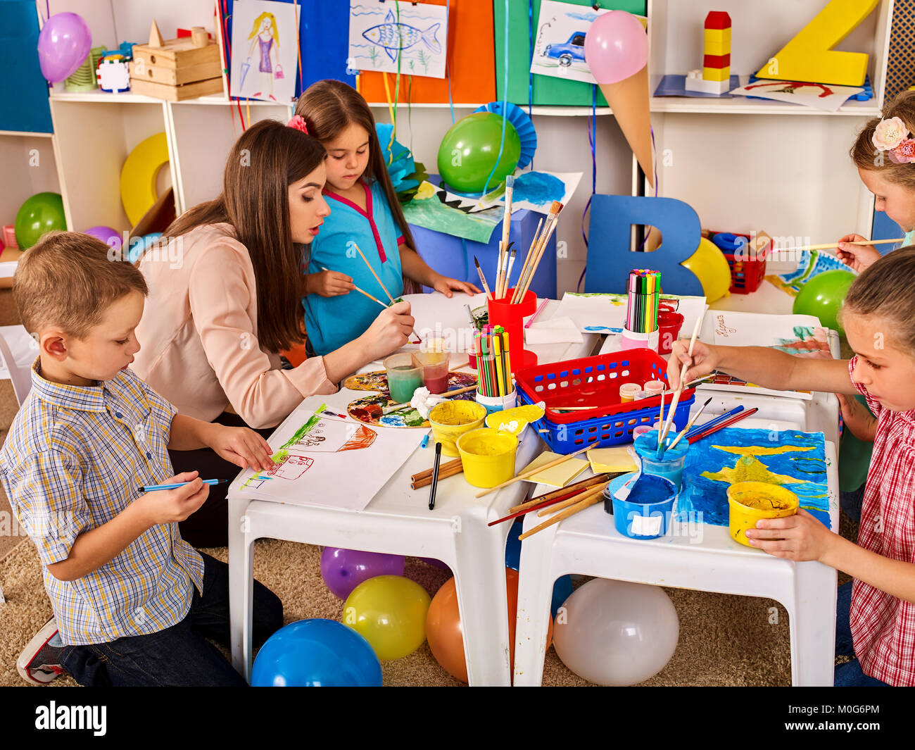Children painting and drawing together. Craft lesson in primary school ...