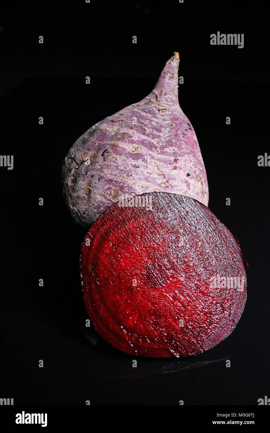 Beet beetroot. Whole and half cutted beet beetroot on black reflective ...