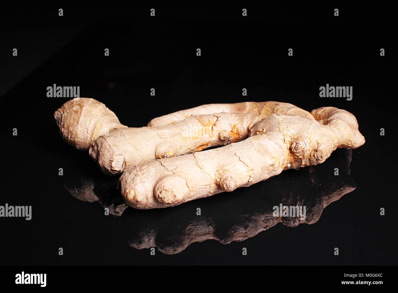 Ginger. Whole ginger on black reflective studio background. Isolated ...
