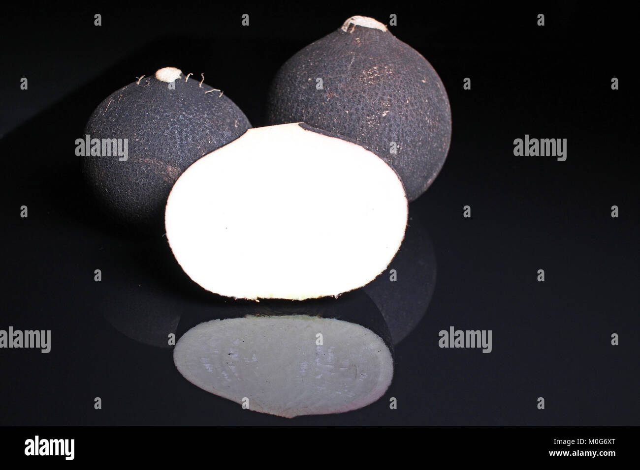 Black raddish. Whole black raddishes on black reflective studio ...