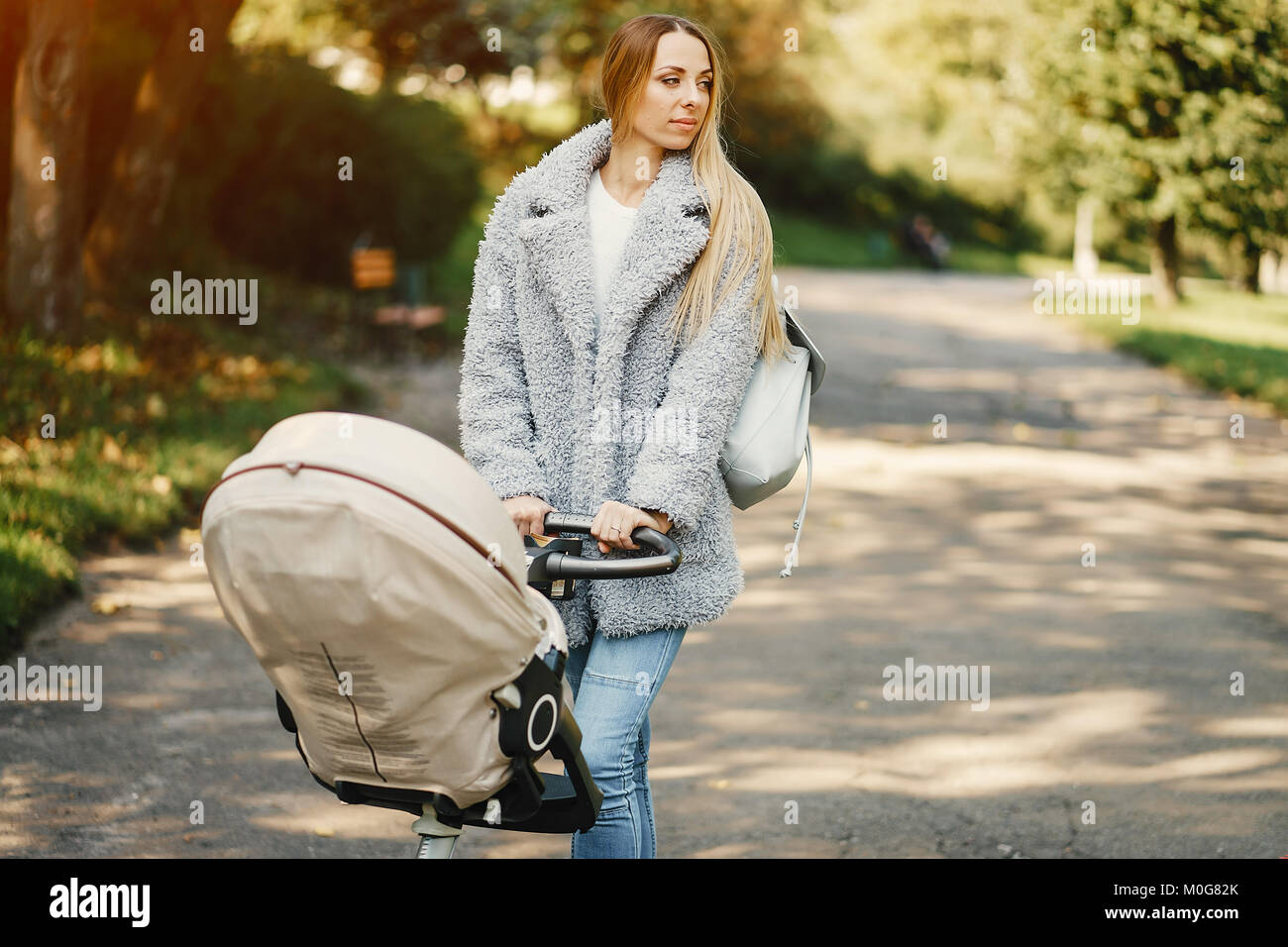 young mother pushing a stroller Stock Photo - Alamy