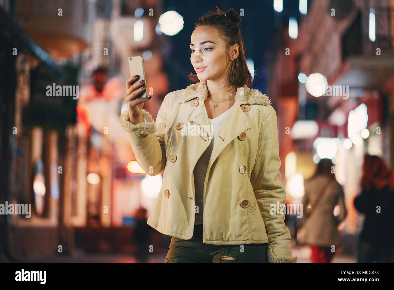 girl checking her phone outside at night Stock Photo - Alamy